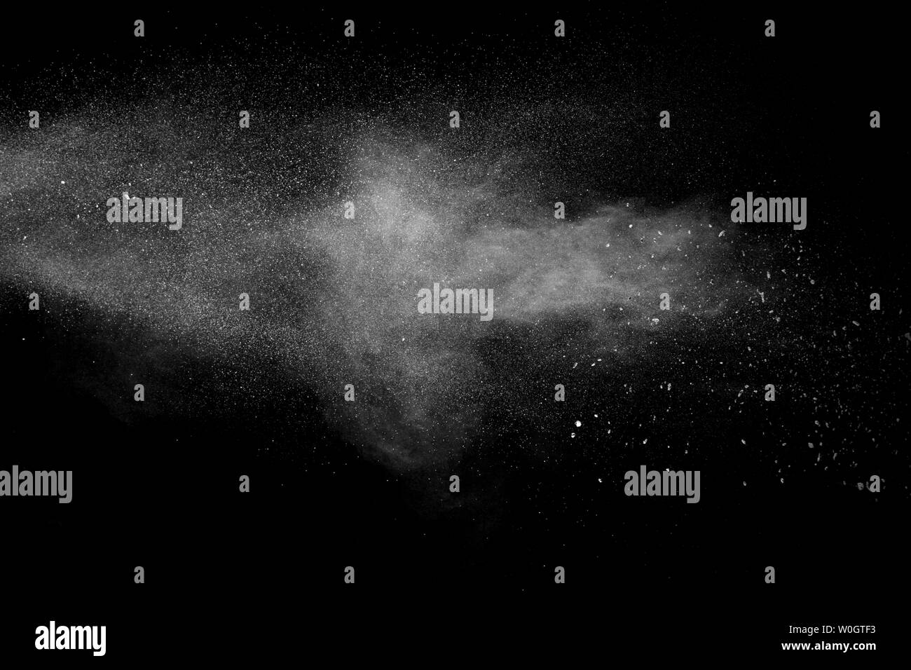 Freeze motion of white dust particles on black background. White powder ...