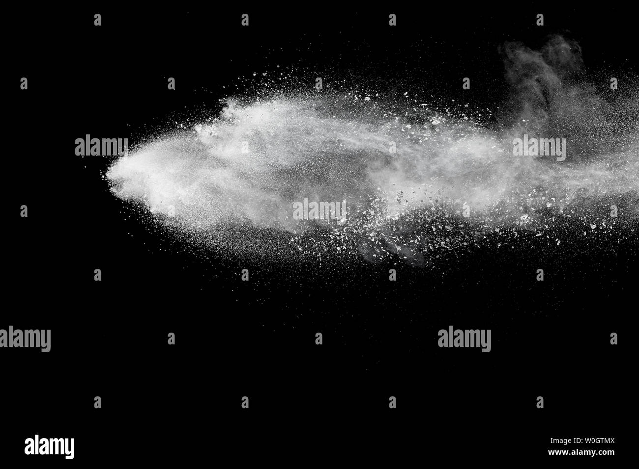 Freeze motion of white dust particles on black background. White powder ...