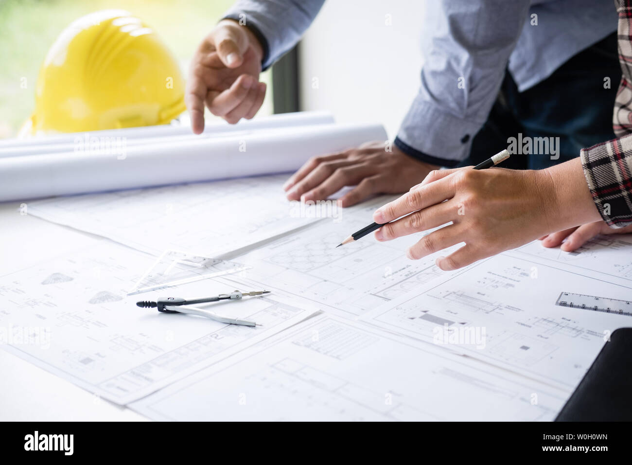 Construction engineering or architect discuss a blueprint while ...