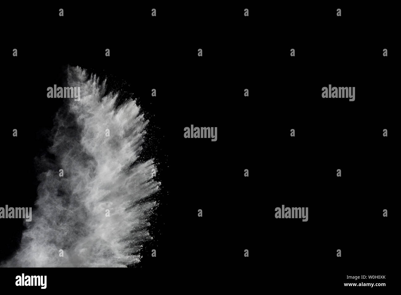 Bizarre forms of white powder explosion cloud against black background ...