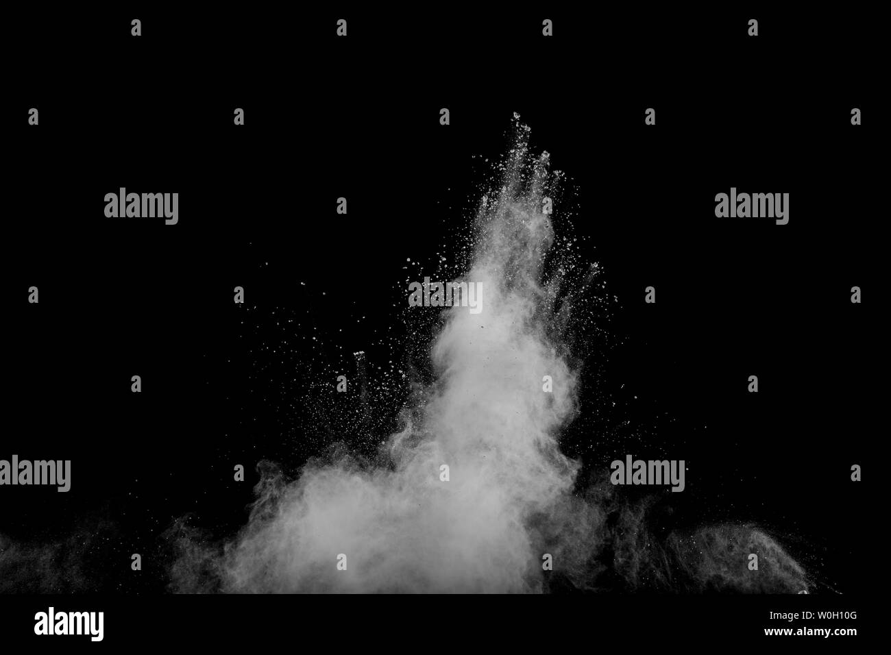 Bizarre forms of white powder explosion cloud against black background ...