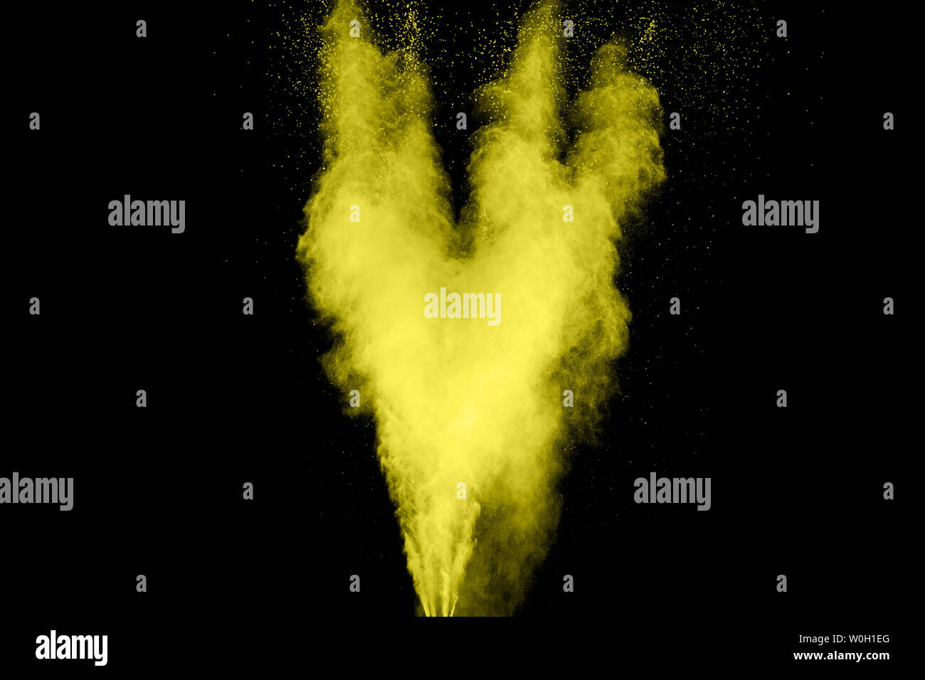 Yellow color powder explosion on black background Stock Photo - Alamy