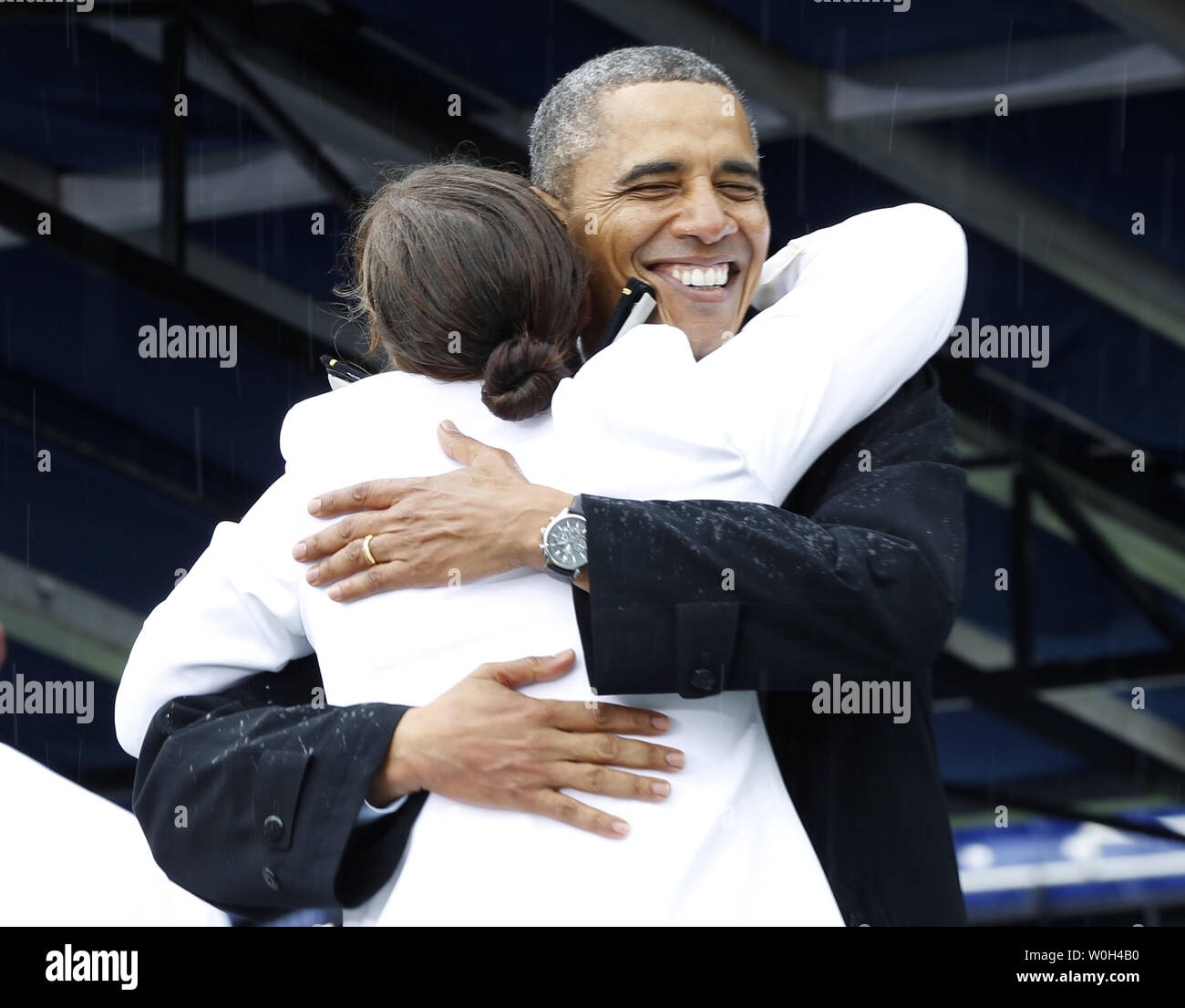 President Barack Obama hugs the last graduate to come on stage at the U ...