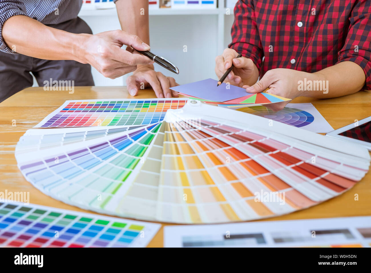 Teamwork of young creative designers working on project together and ...