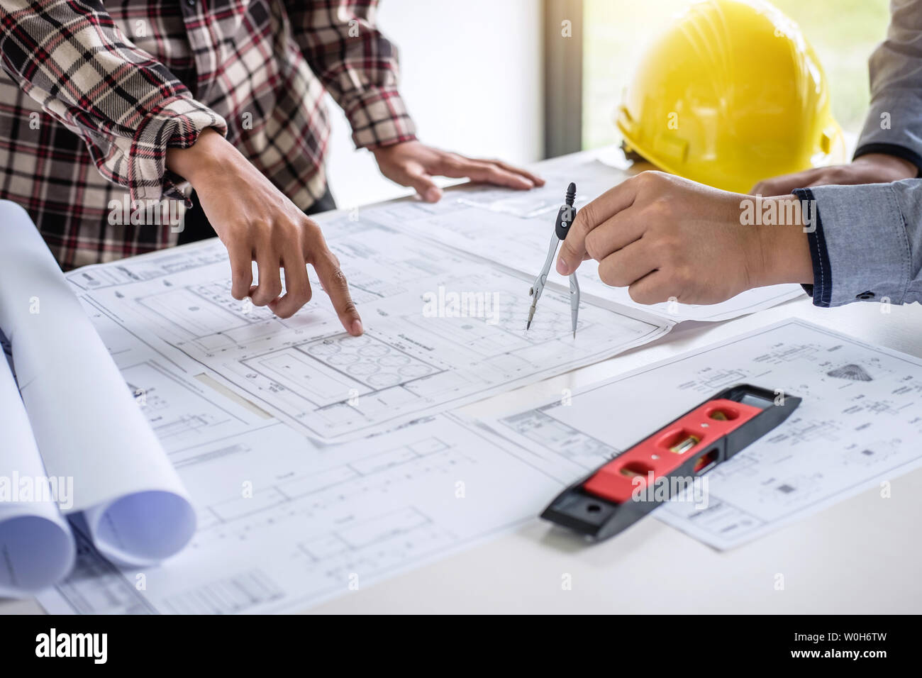 Construction engineering or architect discuss a blueprint while ...