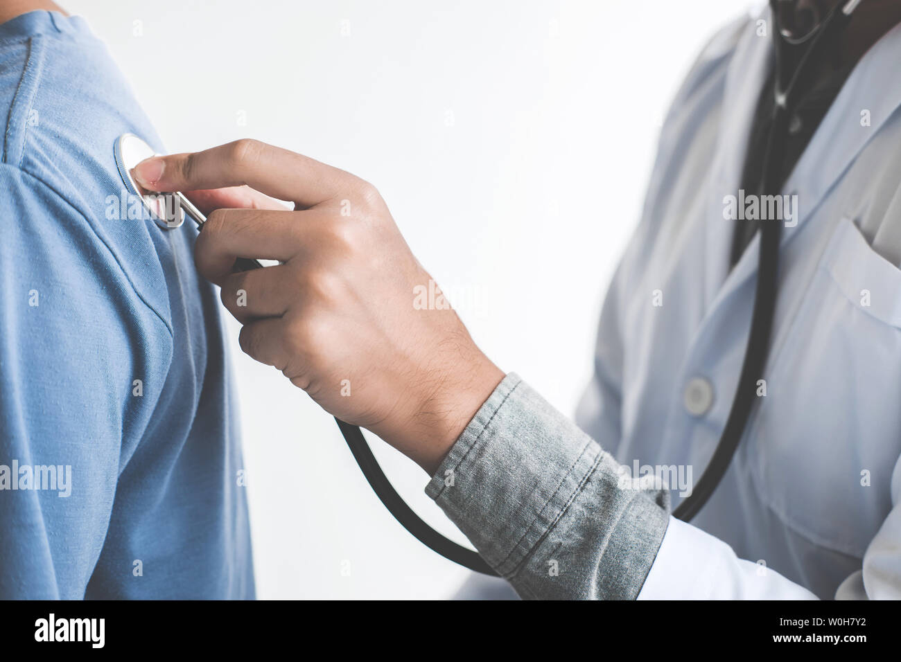 Doctor checking patient with stethoscope listening to heartbeat ...
