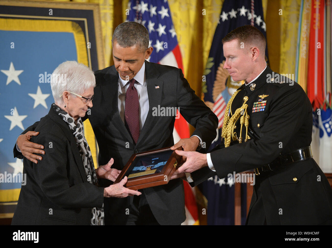 President Barack comforts Obama Nancy Weinstein as she accepts the ...