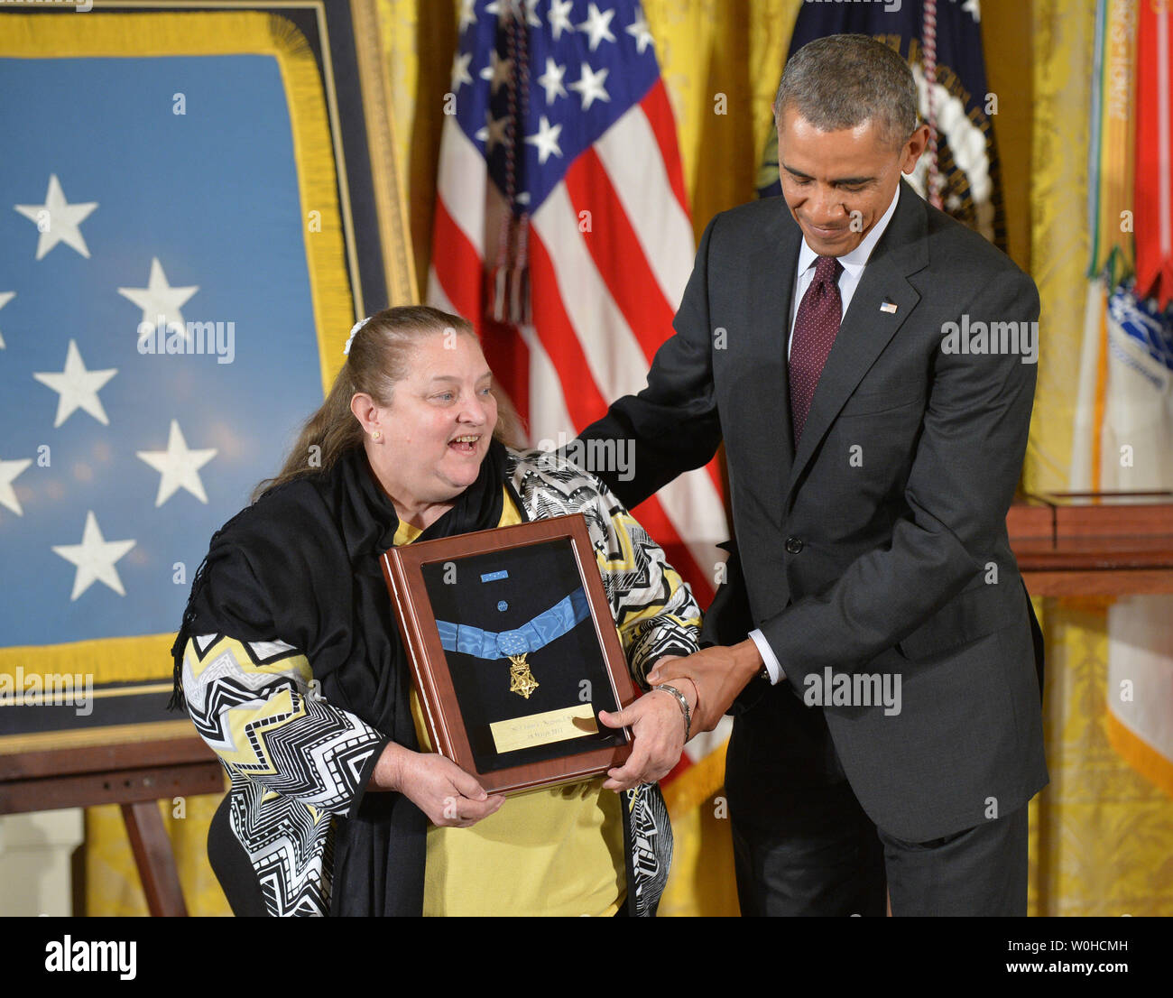 President Barack Obama embraces Iris Negron, who accepted the Medal of ...