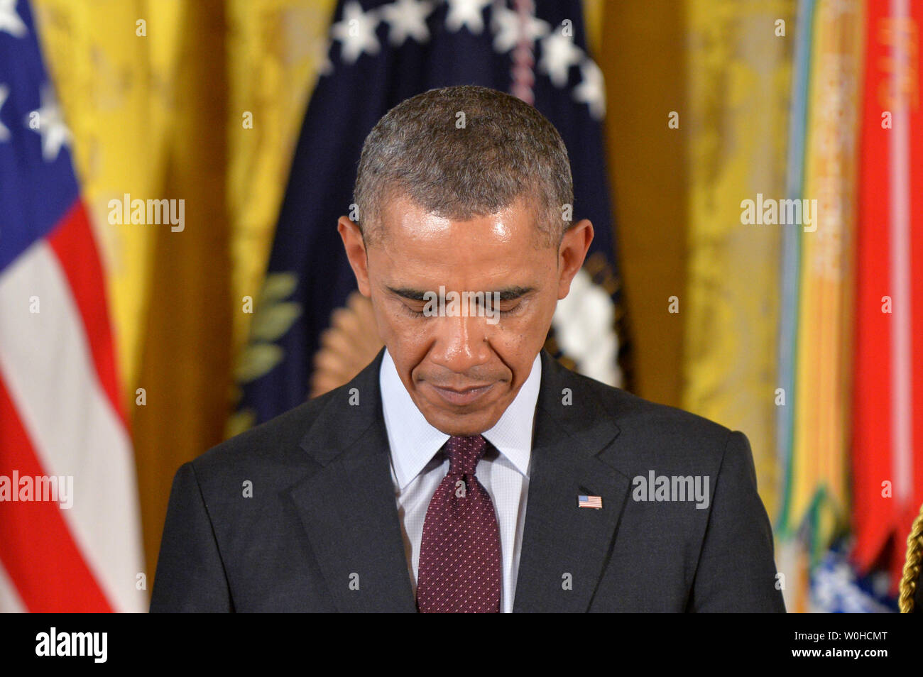 President Barack Obama bows his head during a Medal of Honor ceremony ...