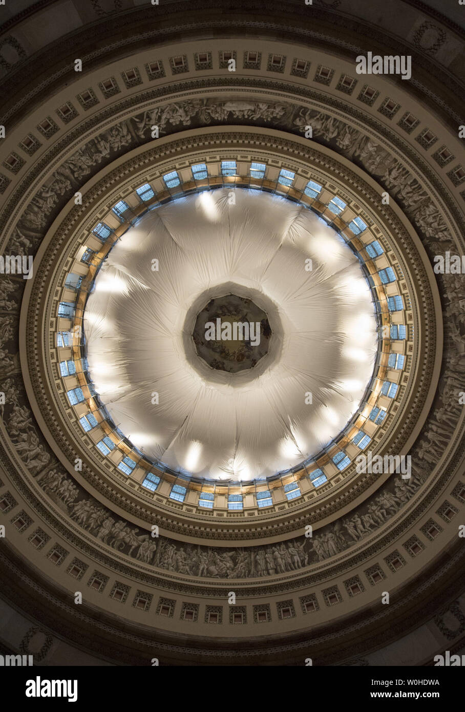 Layers of safety netting and canopies are seen hanging from the top of ...