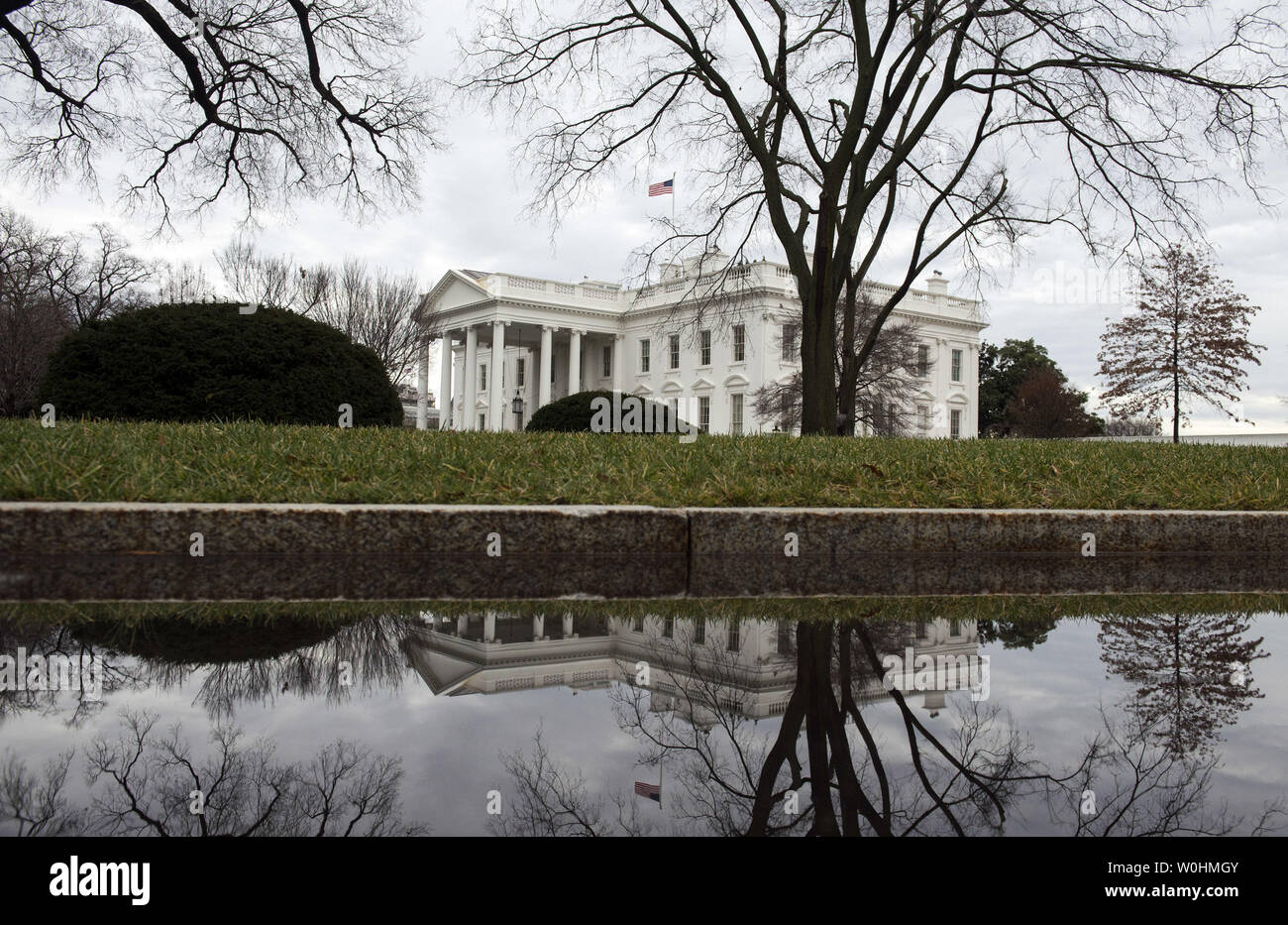 The White House is seen reflected in a puddle, January 4, 2015 in ...