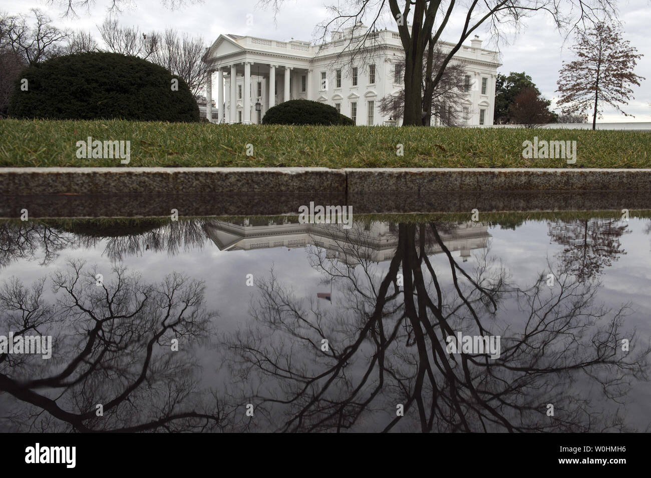 The White House is seen reflected in a puddle, January 4, 2015 in ...