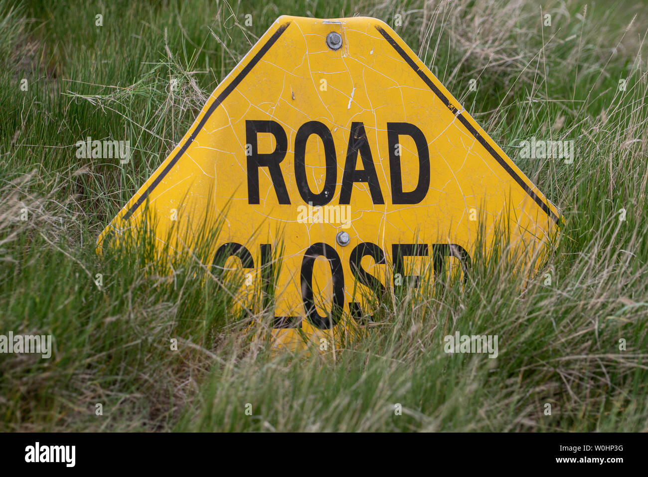 Road closed sign buried in the ground Stock Photo - Alamy