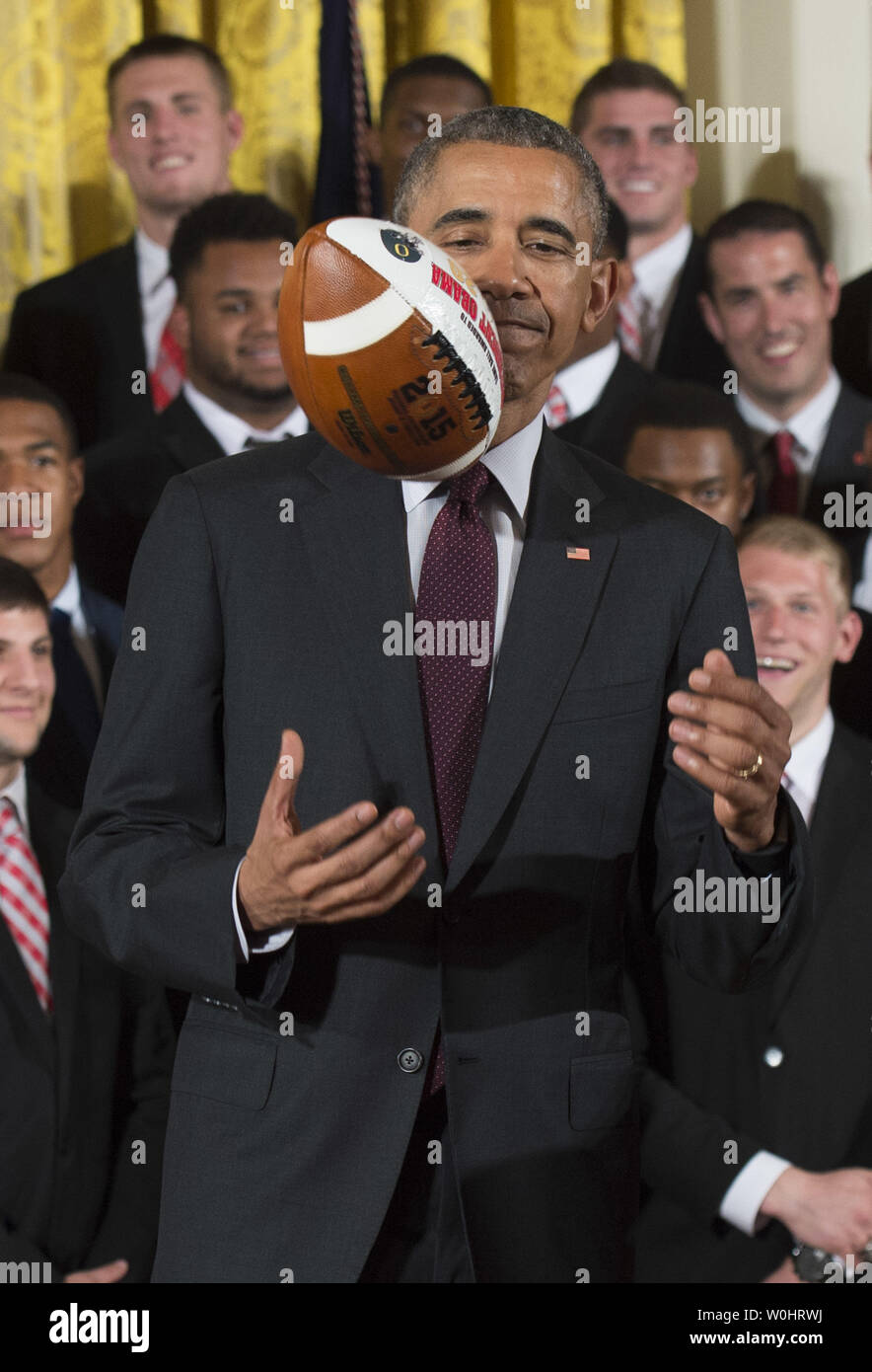 President Barack Obama holds a football as he honors the 2015 College ...