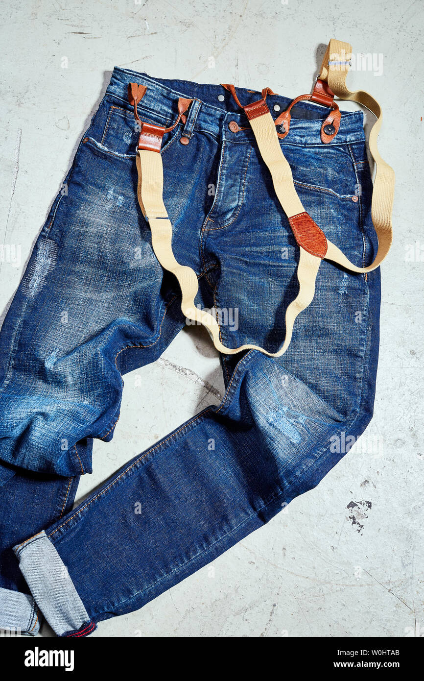 Jeans trousers with suspenders on a concrete floor Stock Photo - Alamy