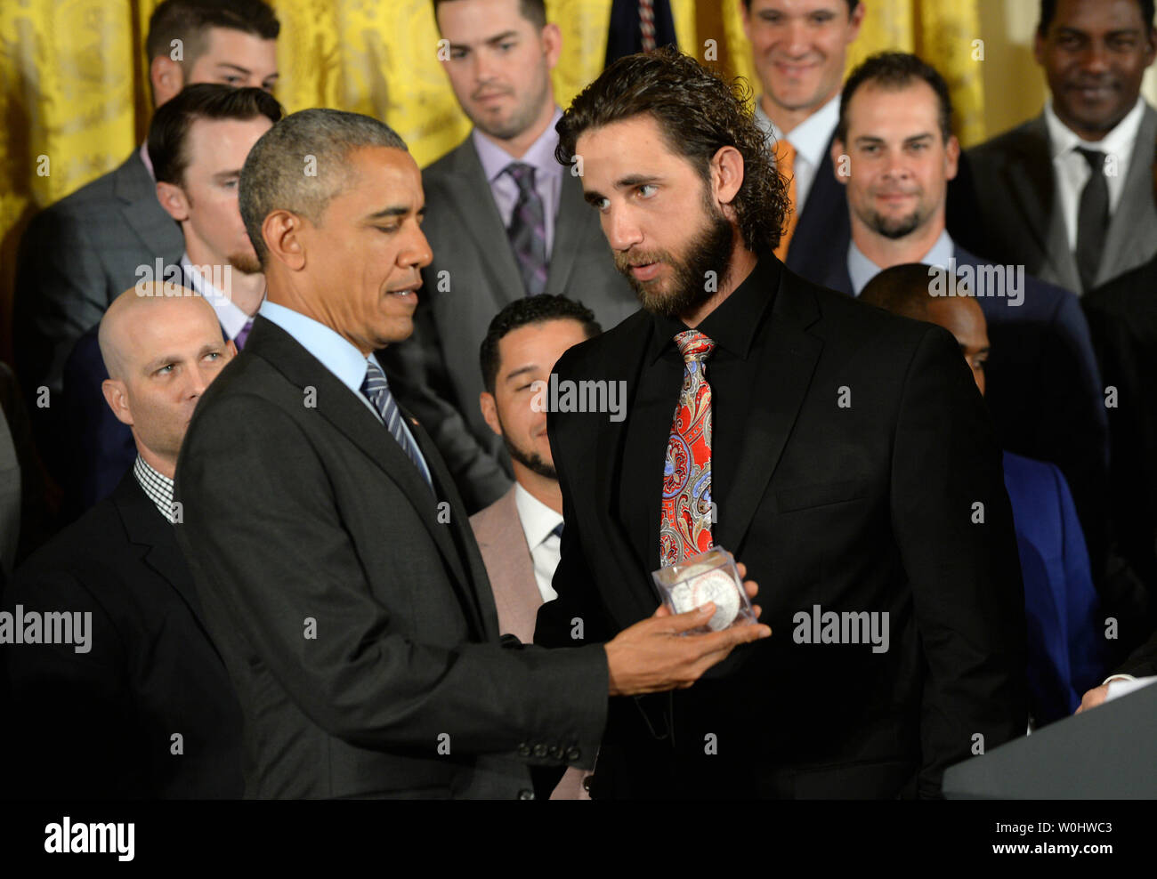 U.S President Barack Obama looks at a team ball given to him by San ...