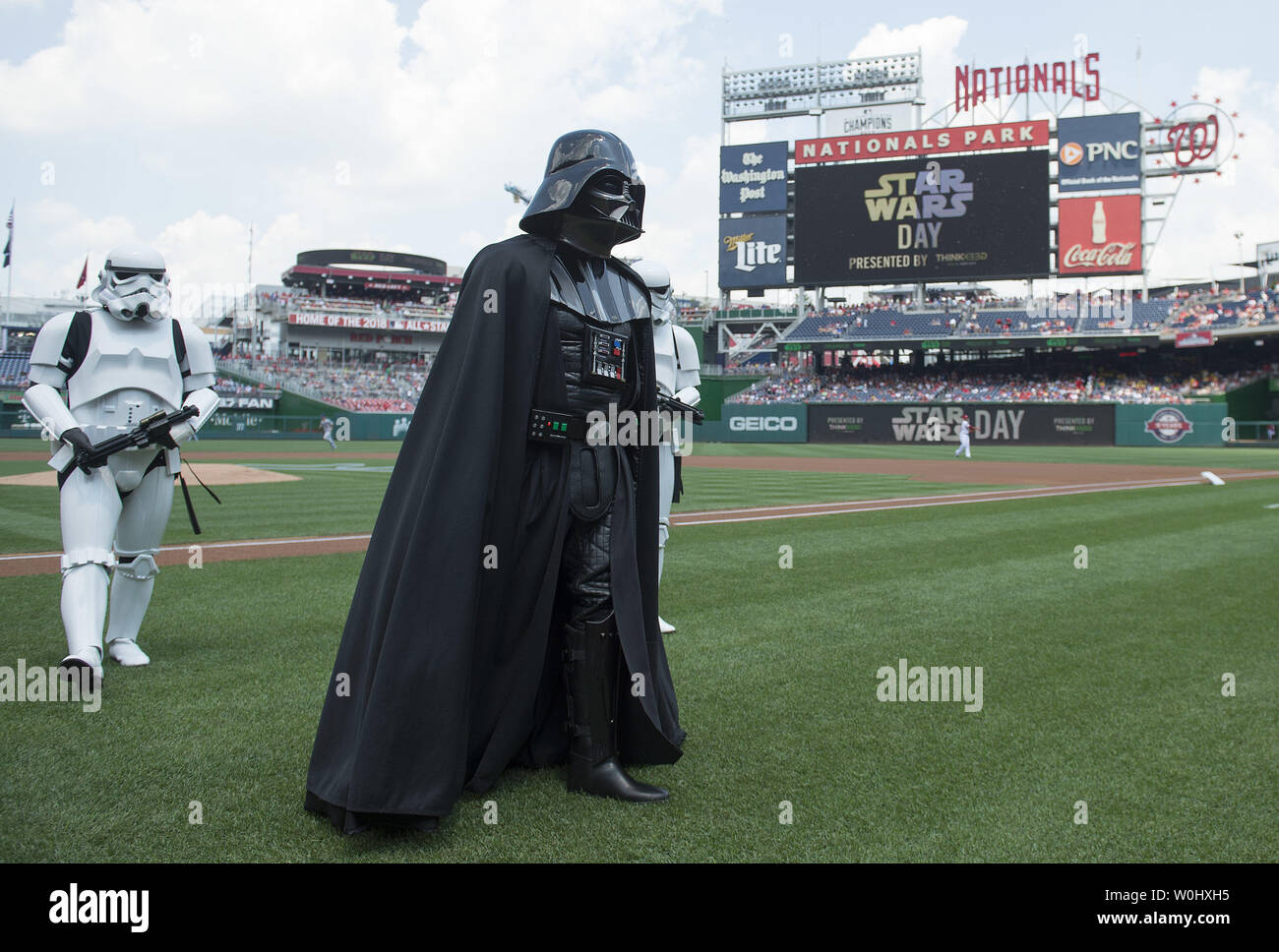 Actors dressed as Darth Vader and Stormtroopers stand on the field ...