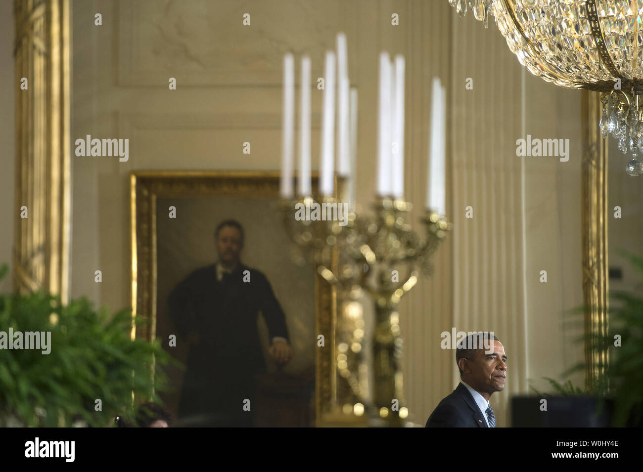President Barack Obama is seen reflected in a mirror as he unveils his ...