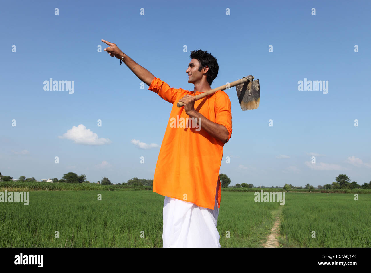 Farmer standing and pointing in a field Stock Photo - Alamy
