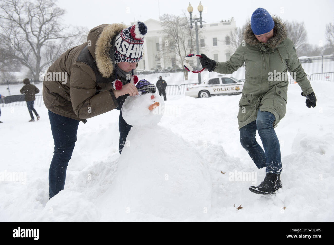 A group of Norwegian tourist build a snowman in front of the White ...