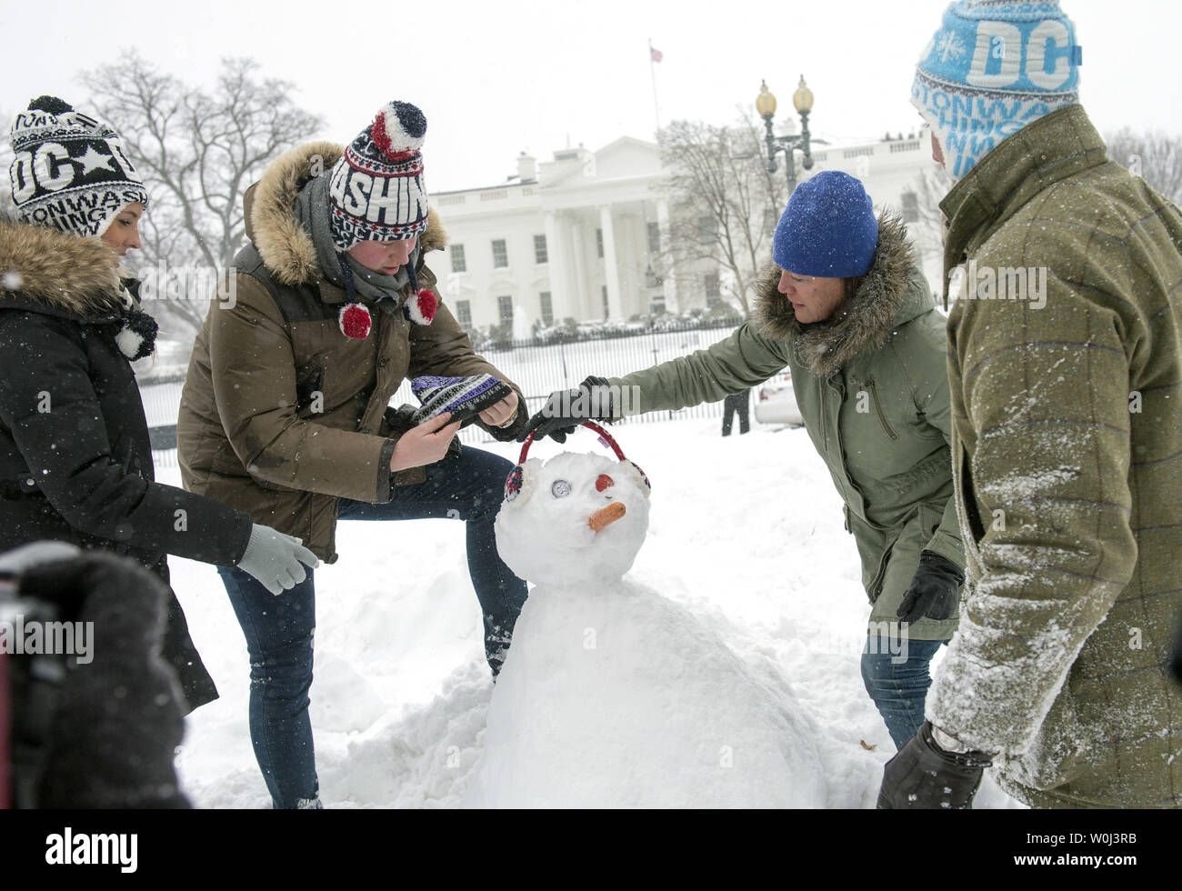 A group of Norwegian tourist build a snowman in front of the White ...