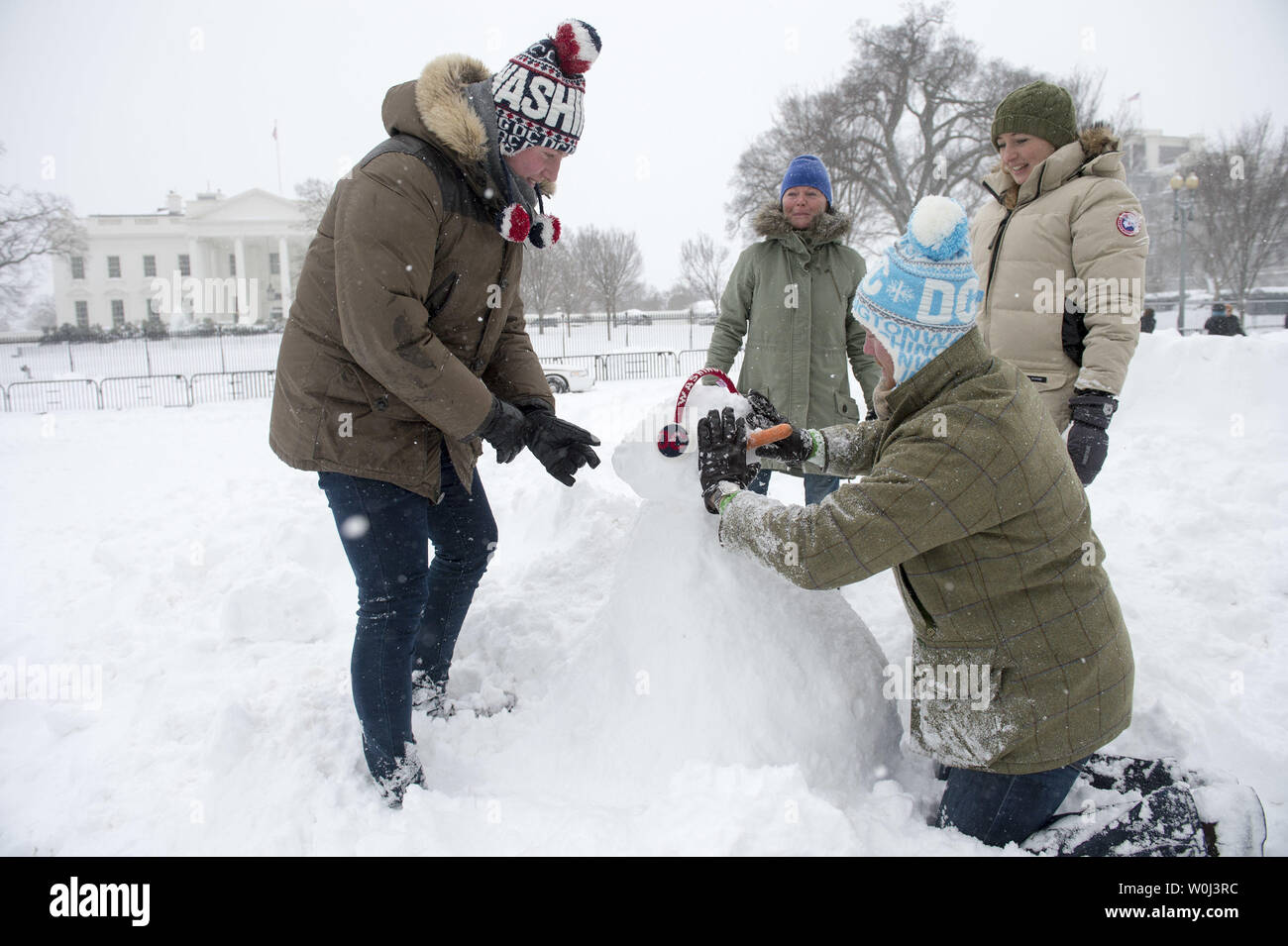 A group of Norwegian tourist build a snowman in front of the White ...