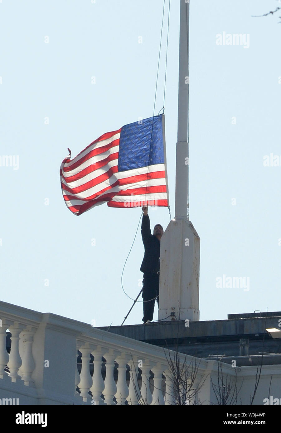 The American flag atop the White House is lowered to half-staff by officials to honor the former ...