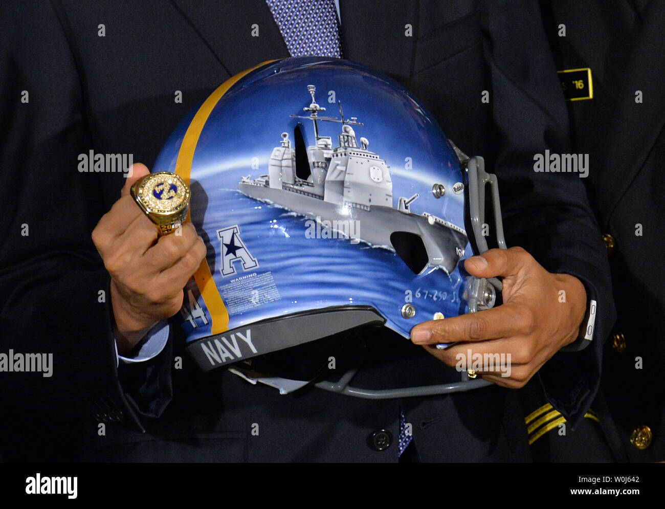 President Barack Obama holds a ring and a helmet given to him as he ...