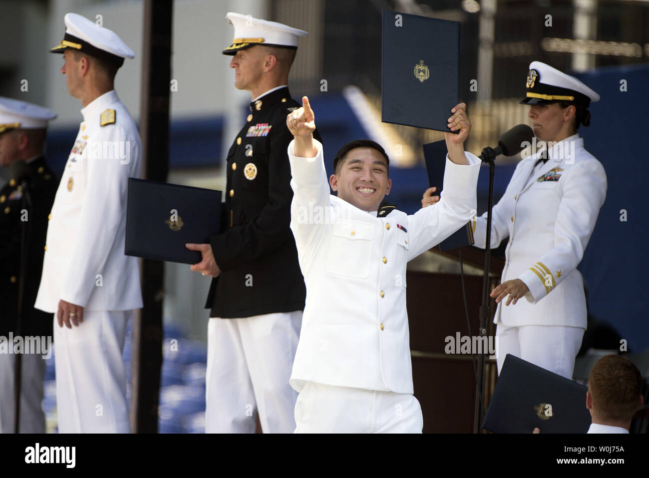 A graduating Midshipmen celebrate after receiving his diploma at the ...