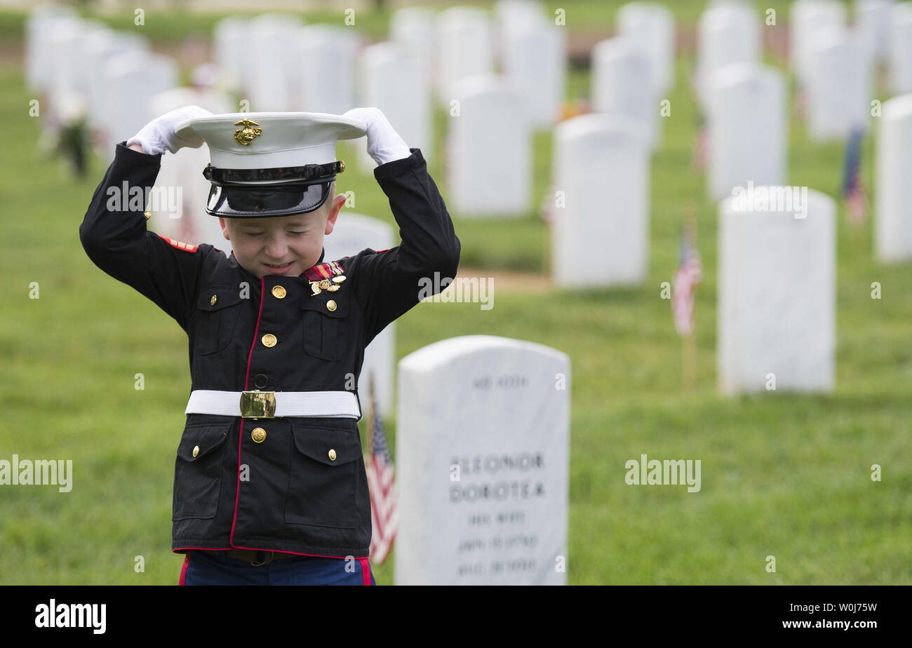 Christian Jacobs, 5, adjusts his hat as he visits the grave of his ...