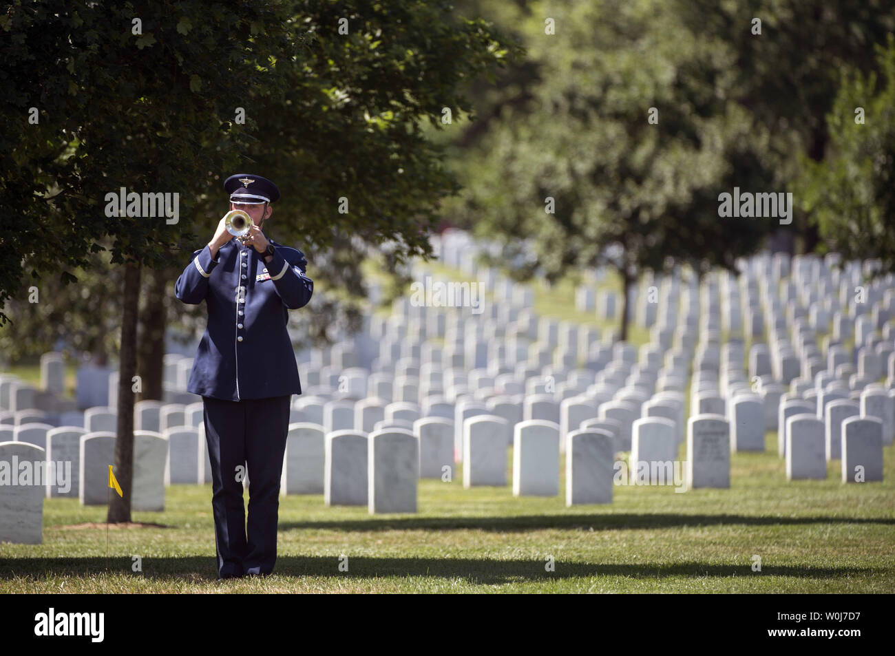 An Air Force Honor Guard bugler plays Taps during the funeral service ...
