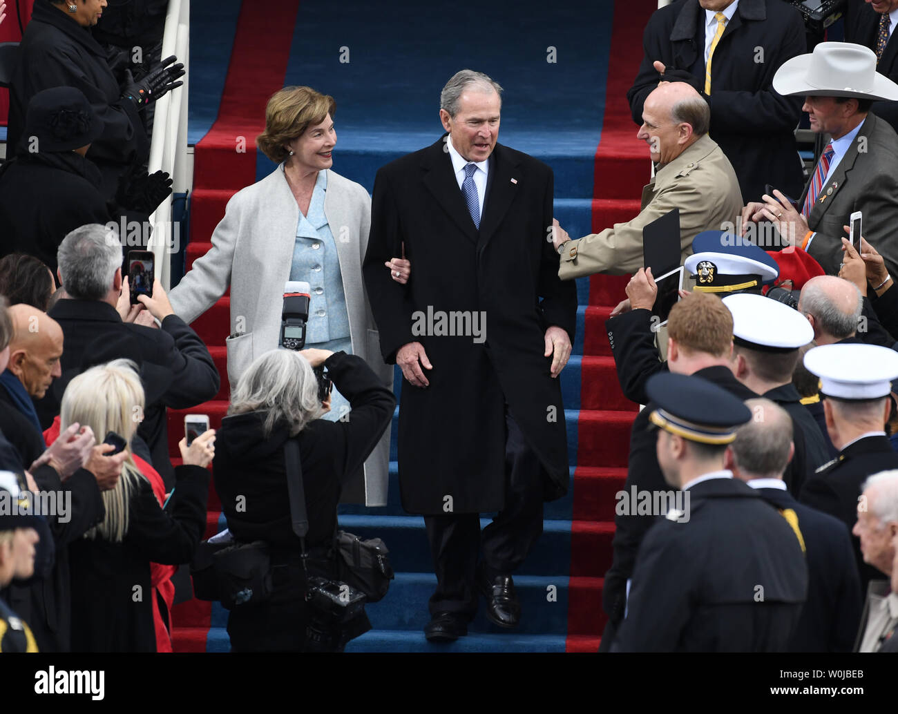 Former President George W. Bush and wife Laura walk down the steps ...