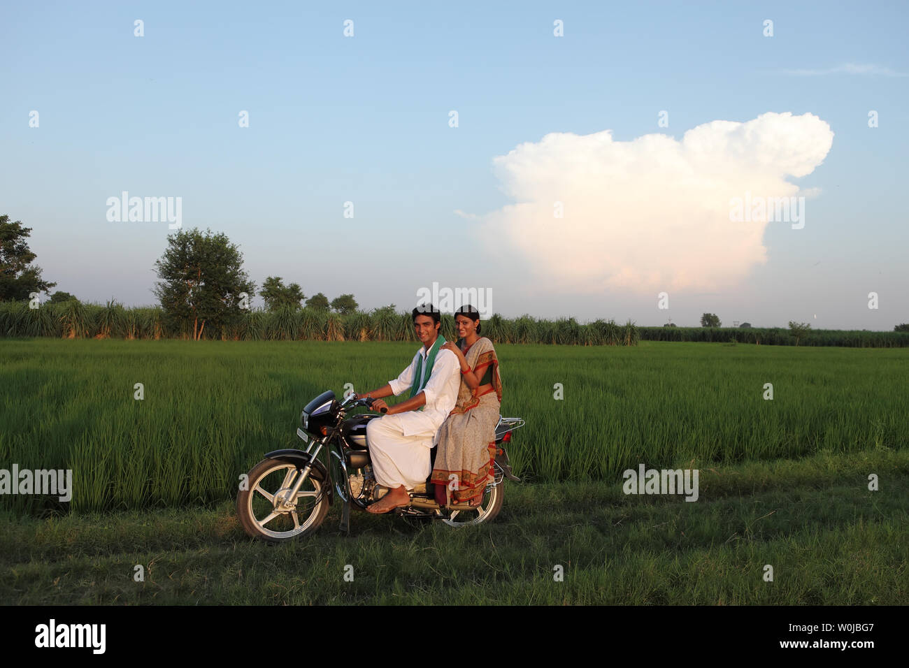 Rural couple riding on a motorcycle in the field Stock Photo - Alamy