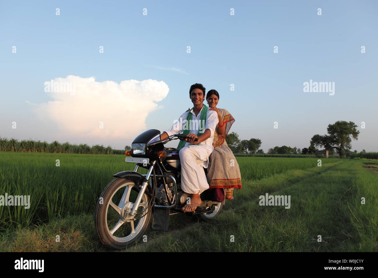Rural couple riding on a motorcycle in the field Stock Photo - Alamy