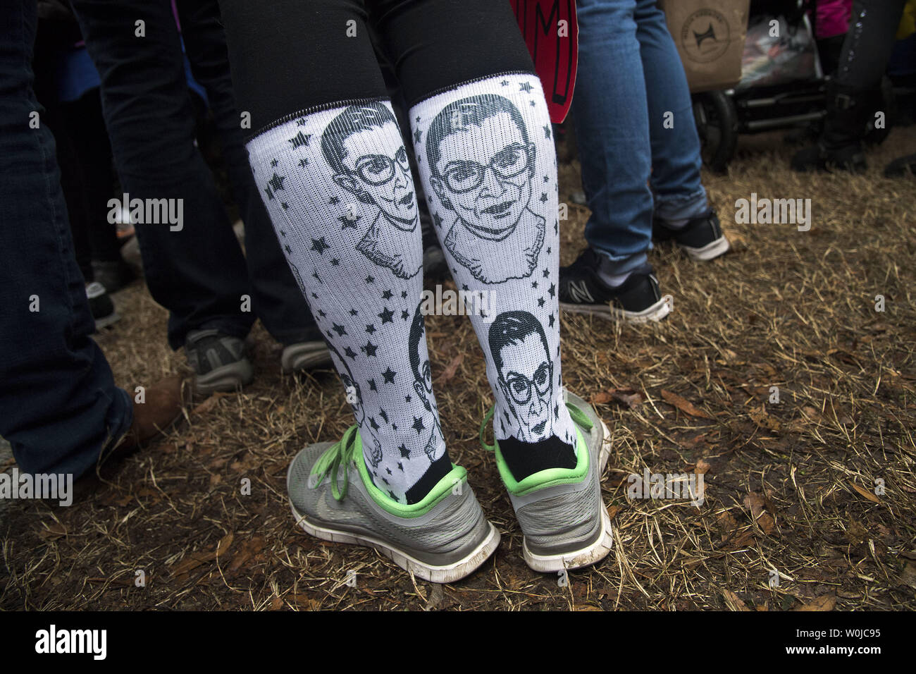 A protester wears socks with Supreme Court Justice Ruth Bater on them ...