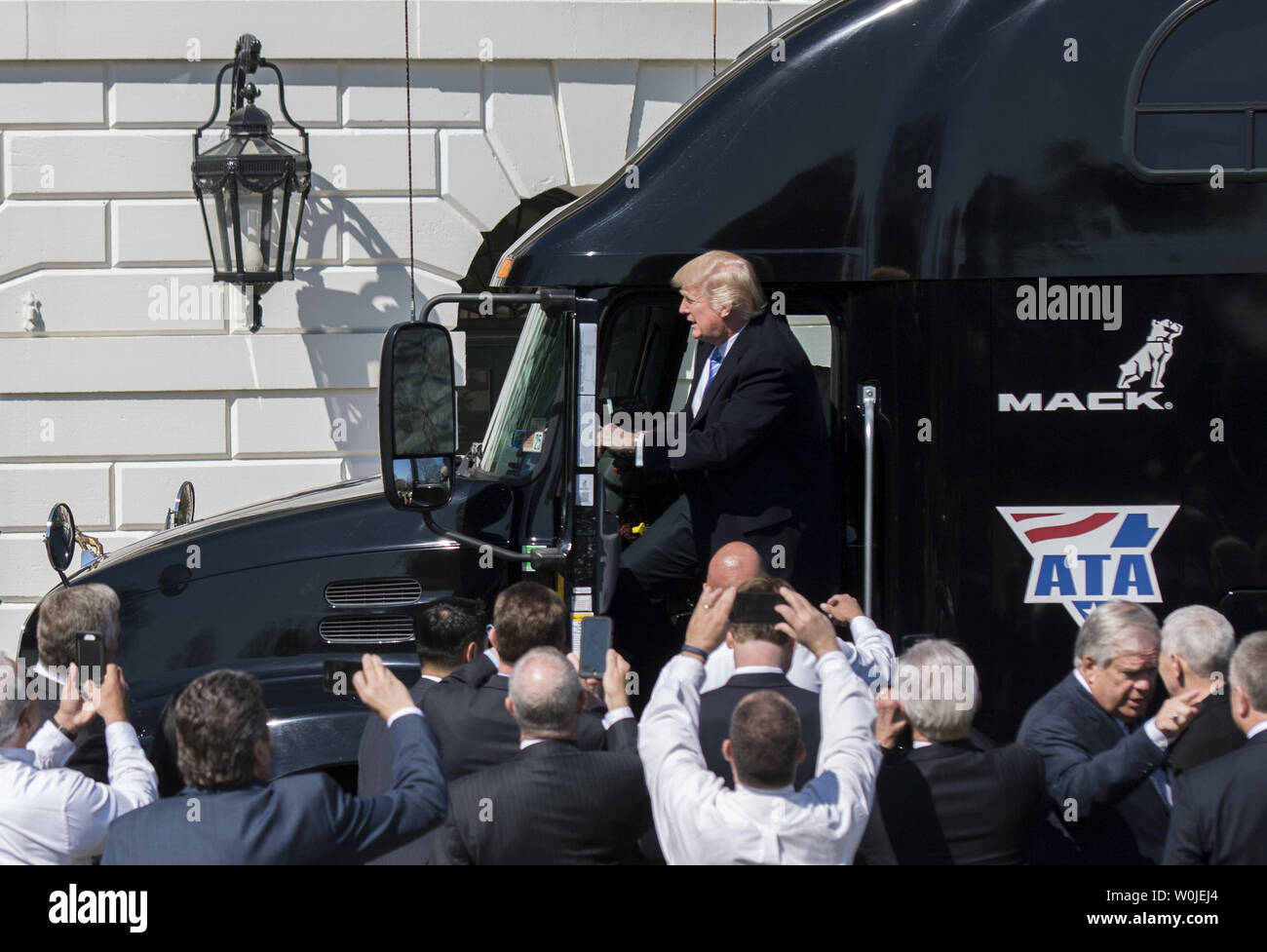 President Donald Trump climbs onto an 18-wheeler truck as he greets ...