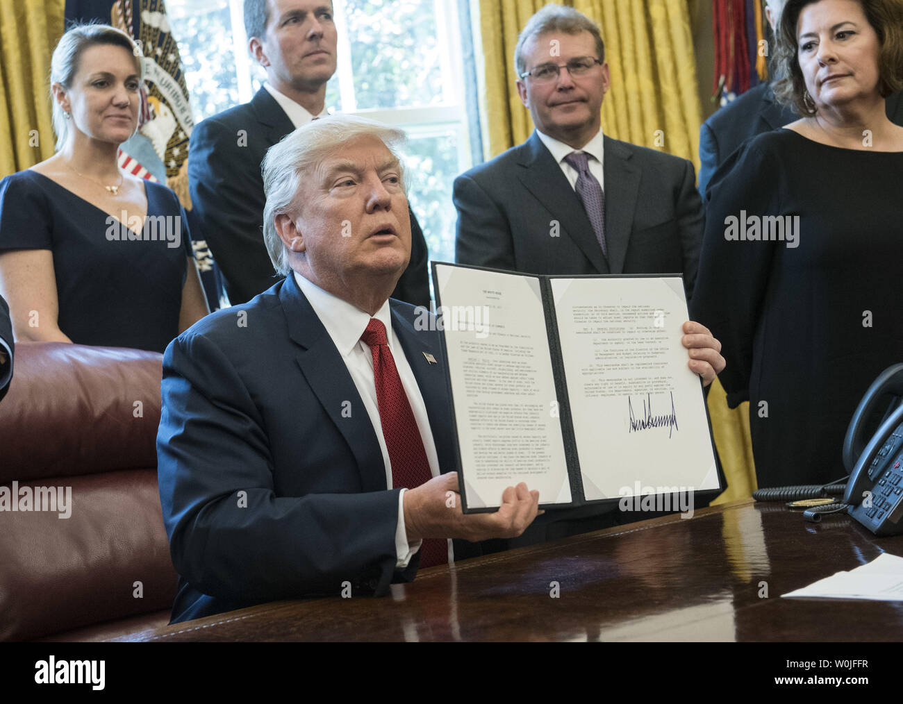 President Donald Trump holds up a signed copy of a Memorandum Regarding ...
