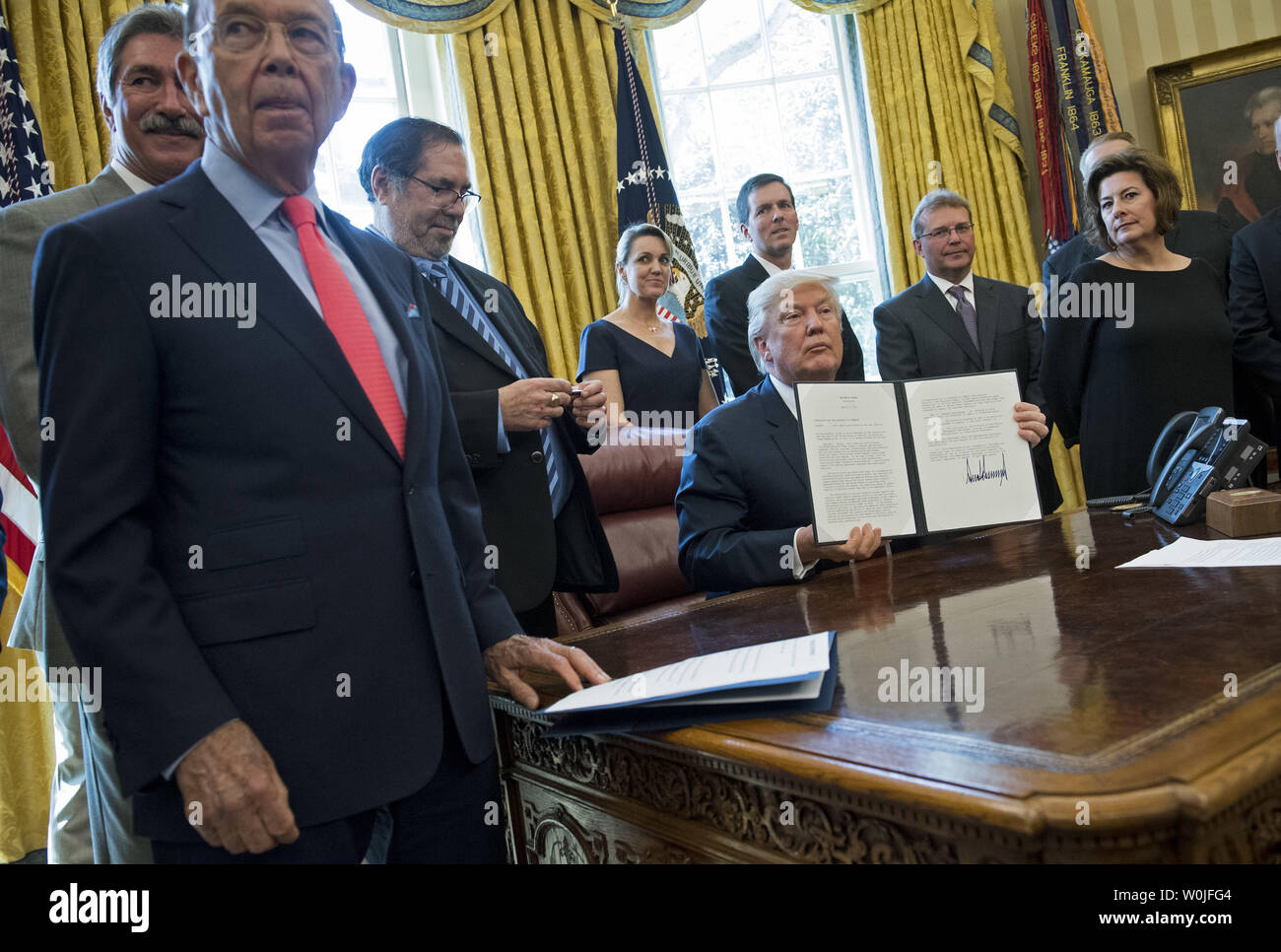 President Donald Trump holds up a signed copy of a Memorandum Regarding ...
