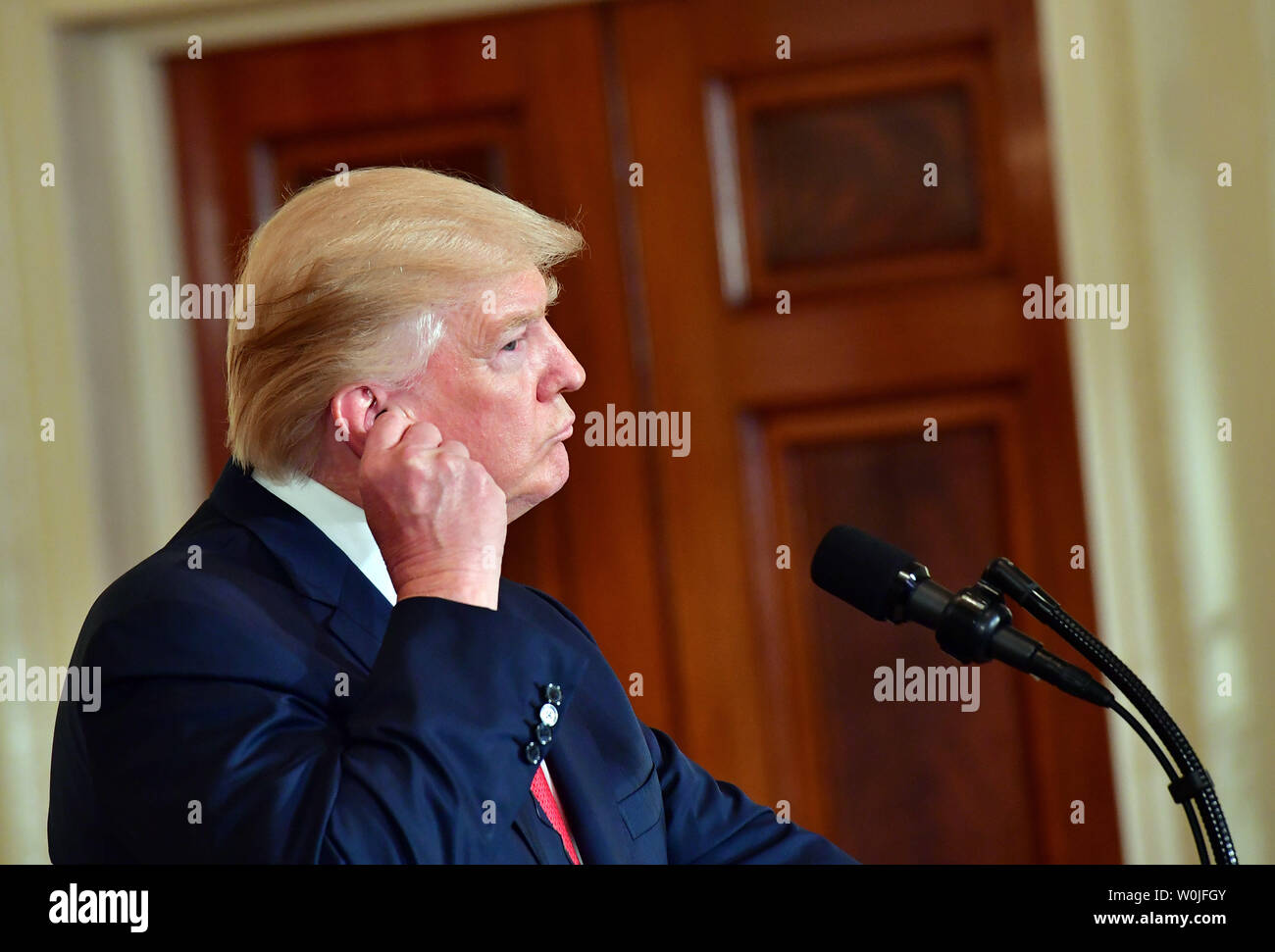 President Donald Trump puts in a translation device during a joint ...