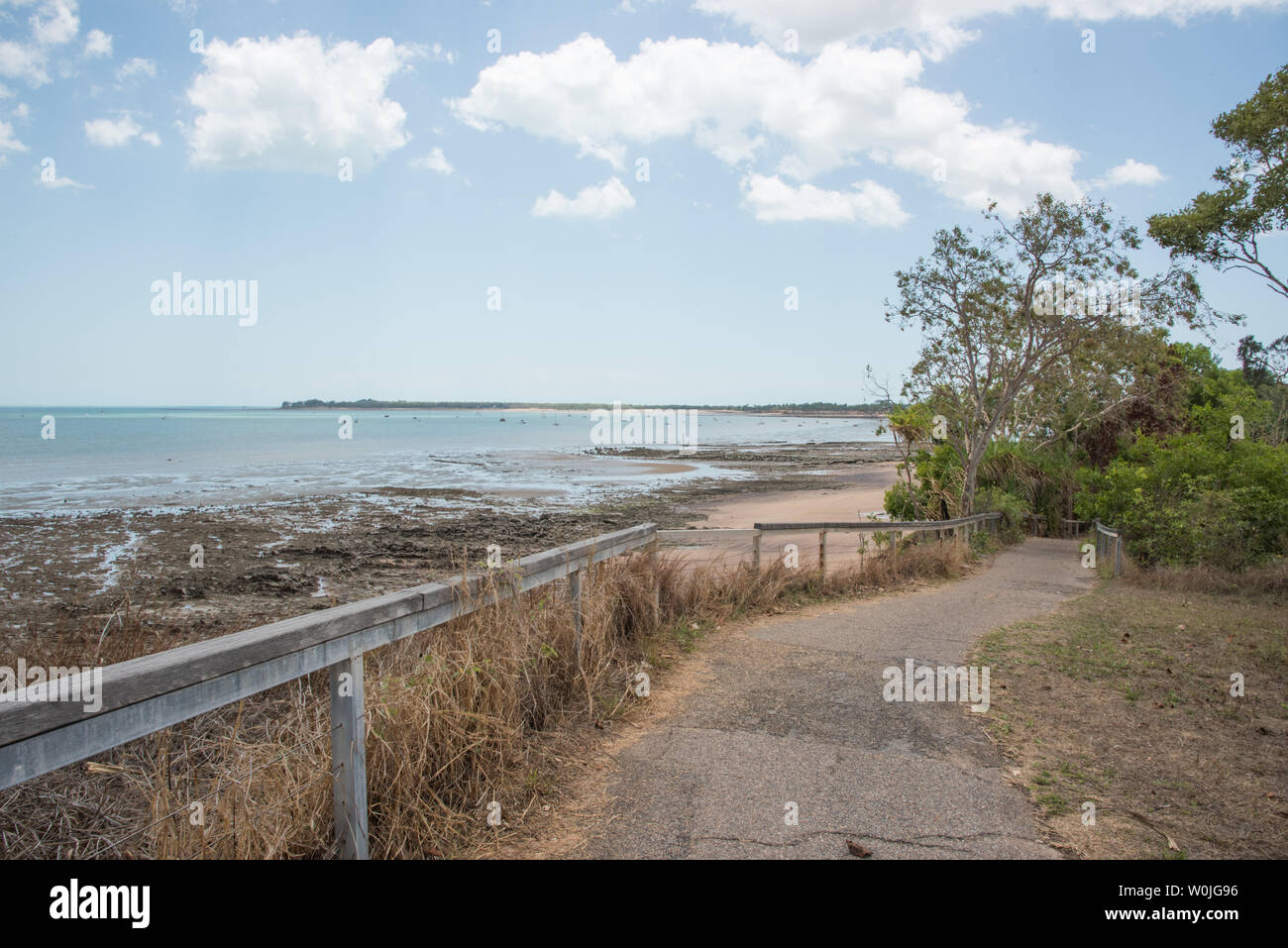 Seaside path with peaceful view, tropical flora and a blue sky with ...