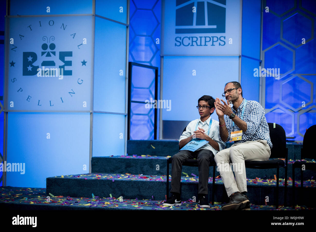 Rohan Rajeev, 14, from Edmond, Okla., sits with his father on stage as ...