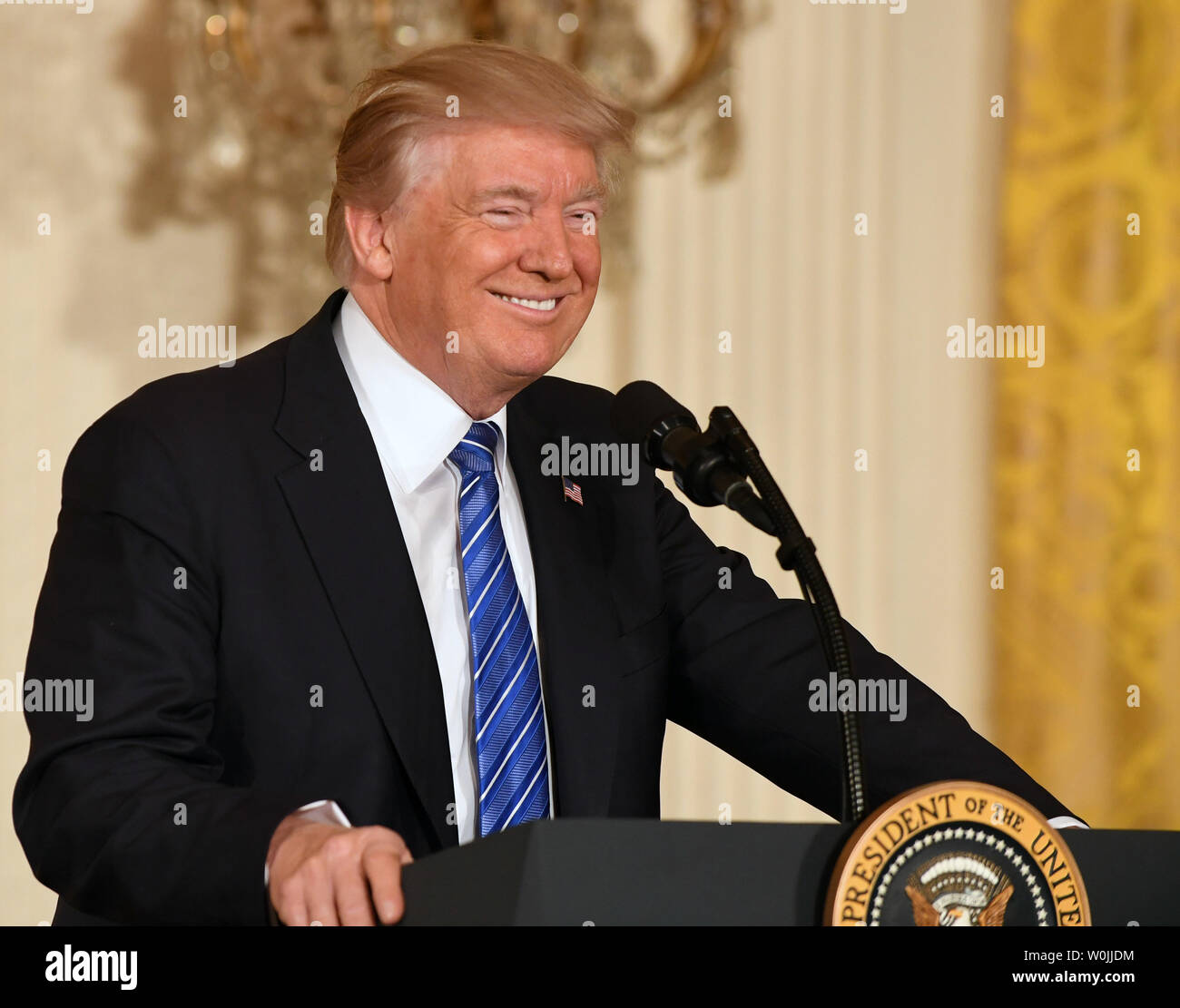 U.S. President Donald Trump smiles while speaking before signing the ...