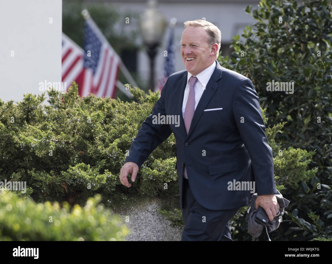 Outgoing White House Press Secretary Sean Spicer walks to the White ...