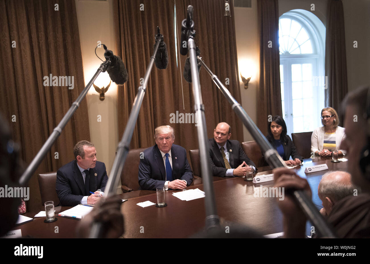 President Donald Trump is seen framed through sound boom microphones as ...