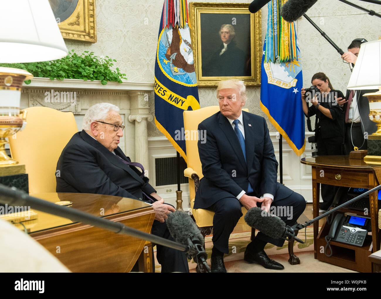 Former Secretary of State Henry Kissinger (L) speaks to the media ...