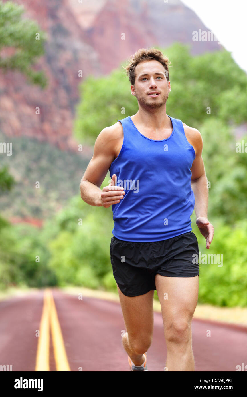 Sport and fitness runner man running on road training for marathon run ...