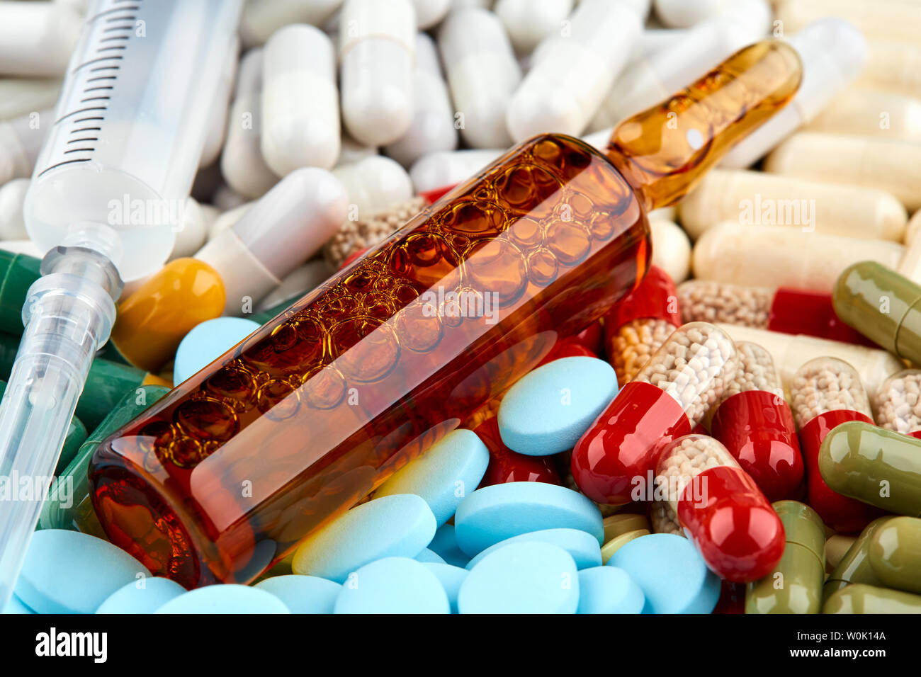 Syringe, brown ampoule and many colorful pills Stock Photo - Alamy