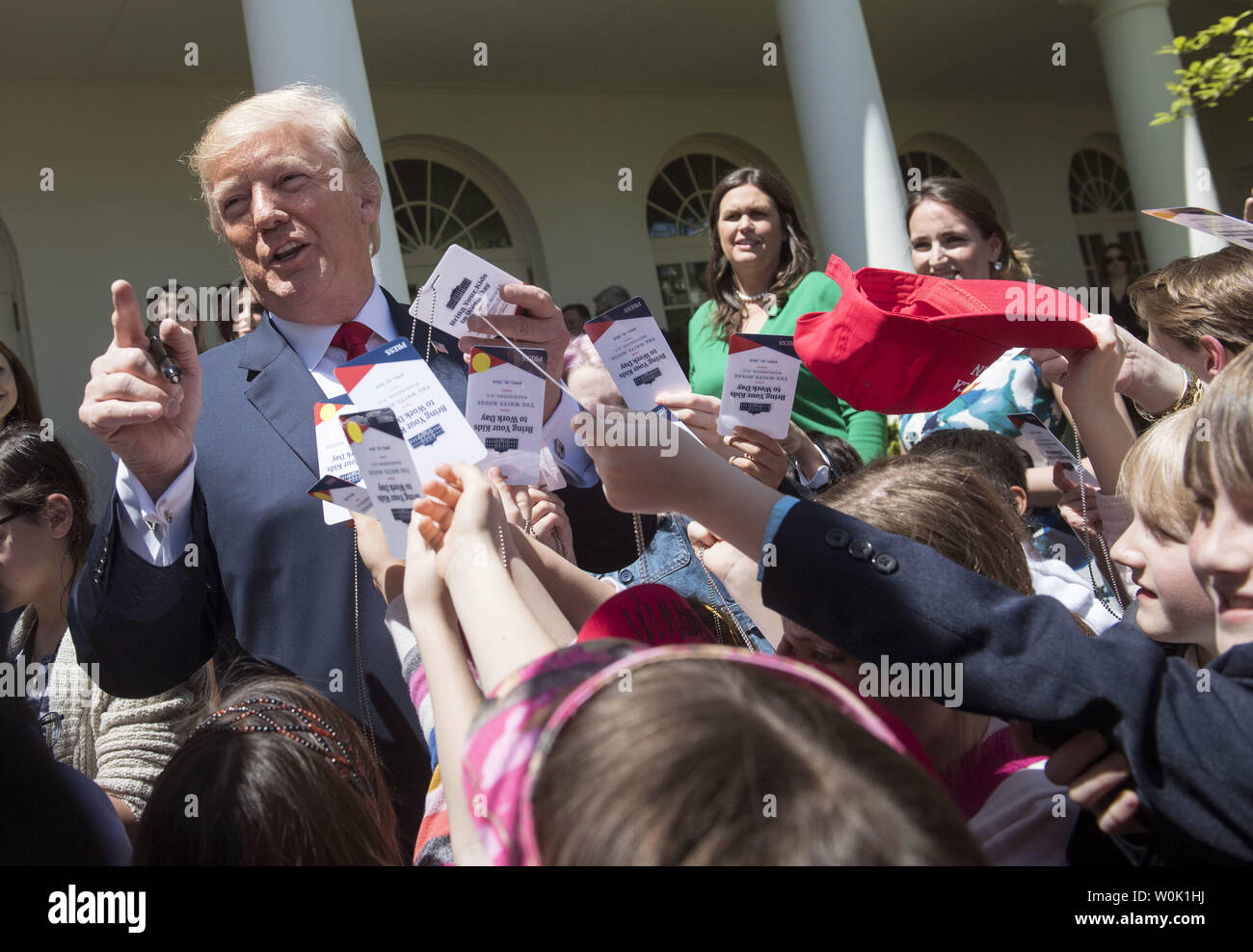 President Donald Trump signs autographs as he meets with children on ...
