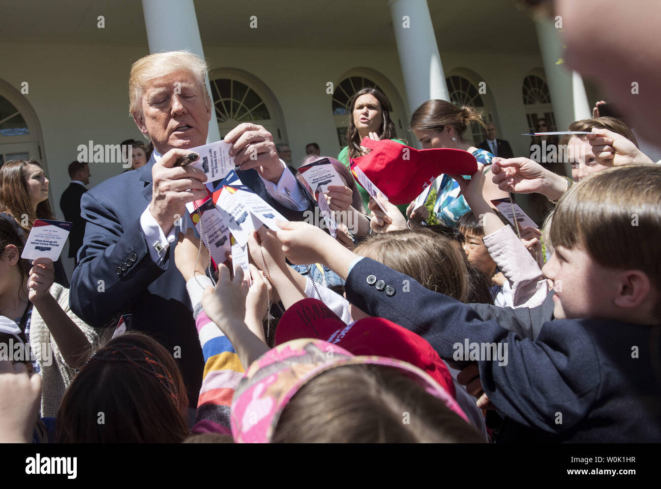 President Donald Trump signs autographs as he meets with children on ...