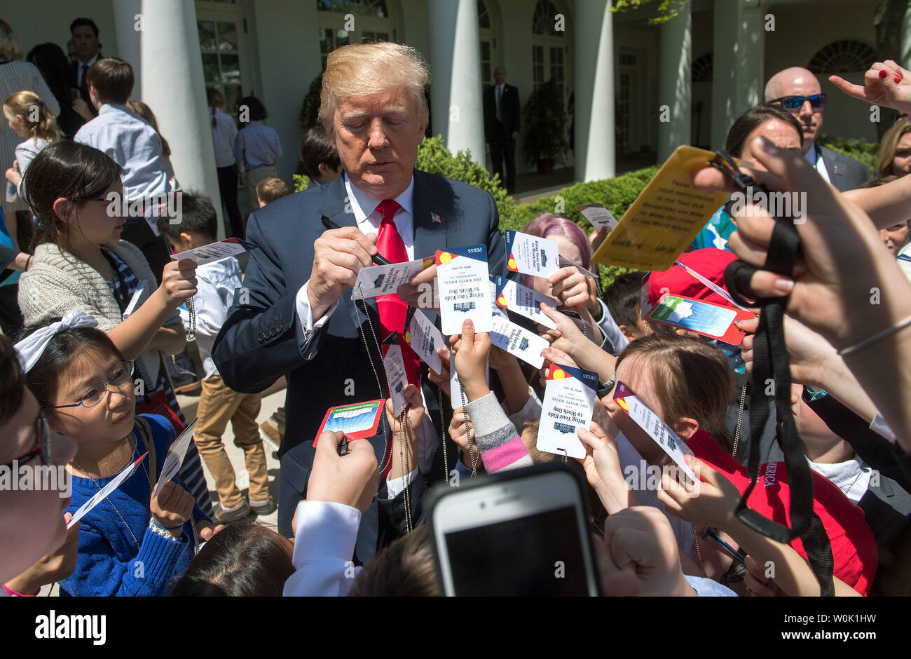 President Donald Trump signs autographs as he meets with children on ...